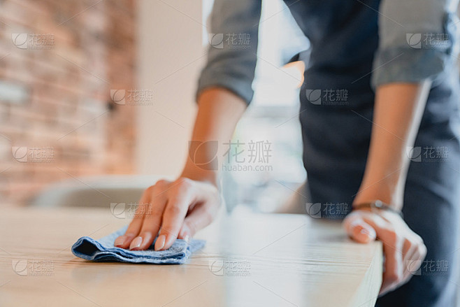 女服务员在自助餐厅擦桌子的镜头:选择性聚焦