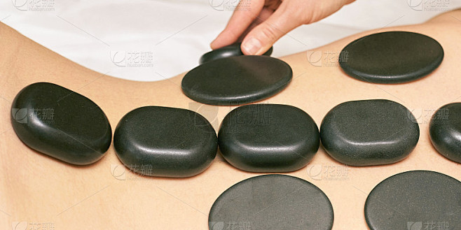 body stone massage. Hot rock masseur. Girl at salo