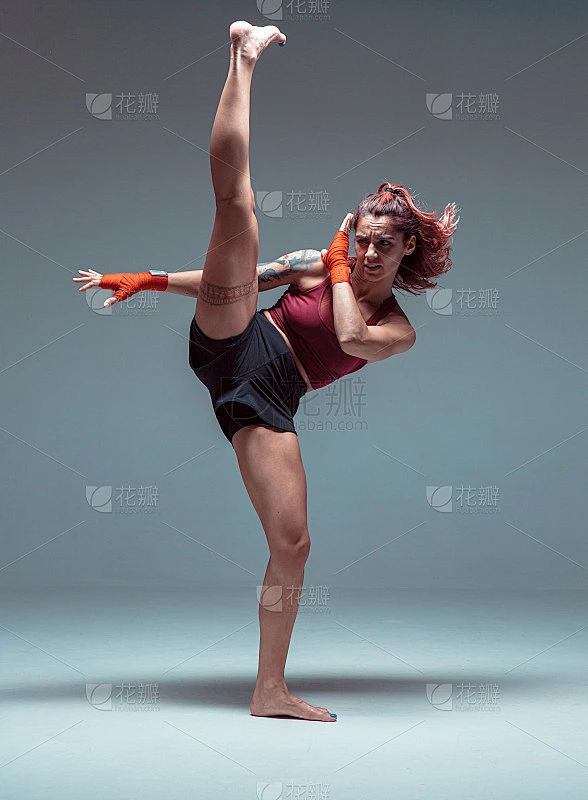 一个年轻的女拳击手表演高踢。素材-花瓣网