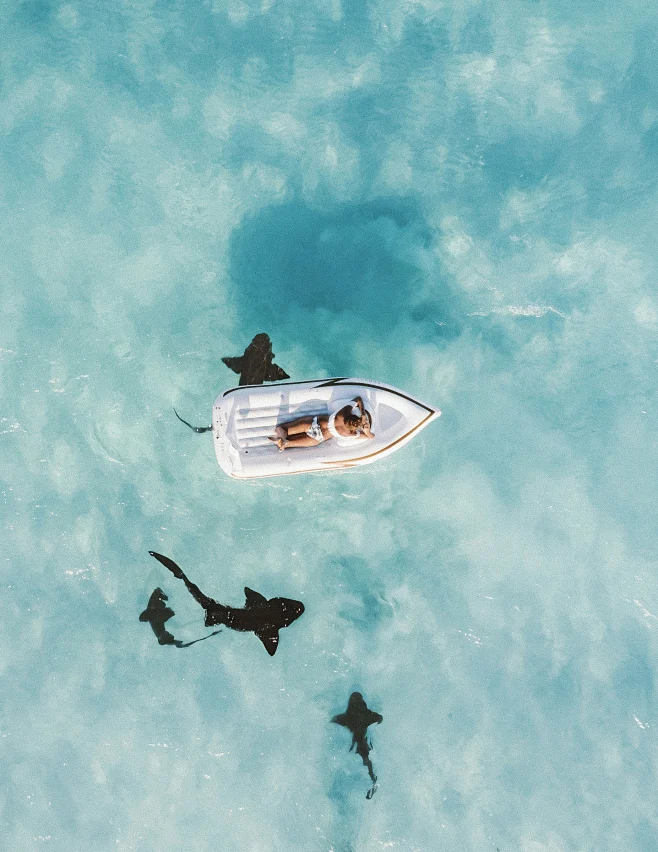 person sun bathing on white inflatable buoy under sunny skies-花瓣网