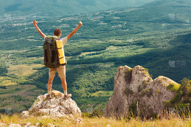 Backpacker on high rock and looking at the big valley