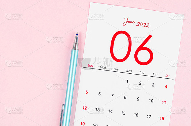 2022年6月日历，粉红色背景上的钢笔。