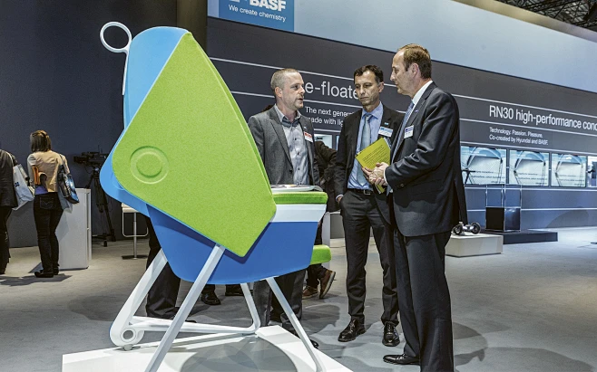Three men in suits look at the BASF TeamUP chair by ITO Design at ...
