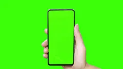 man's hand holding a mobile telephone with a vertical green screen in tram chroma key smartphone ...