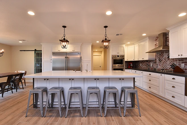 Example of a large farmhouse l-shaped light wood floor and brown floor ...