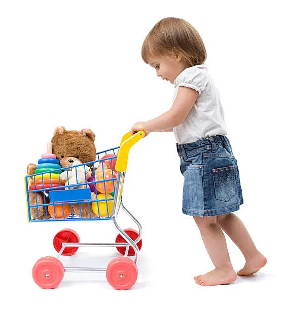 caucasian female toddler with toy shopping cart on white - cute baby ...