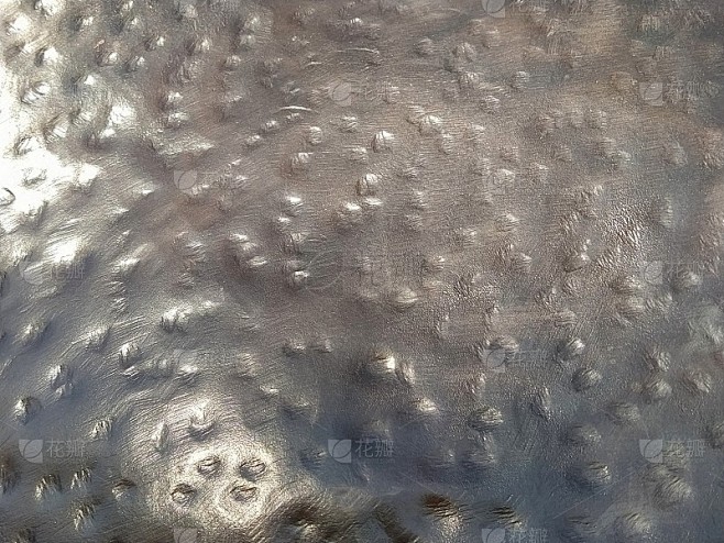 Bent metal with dents. Close-up of a bronze surfac