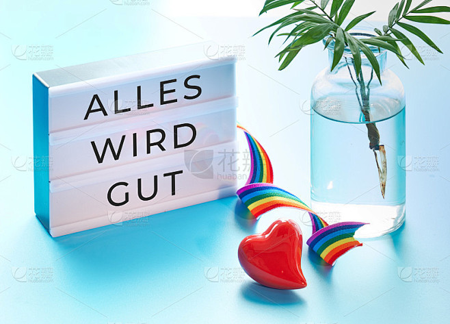 文本“Alles wird gut”在德语中的意思是“一切都会好起来的”在英语中。心脏，彩虹丝带，象