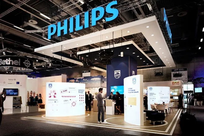 This may contain: people are standing in front of the phillips booth at ...