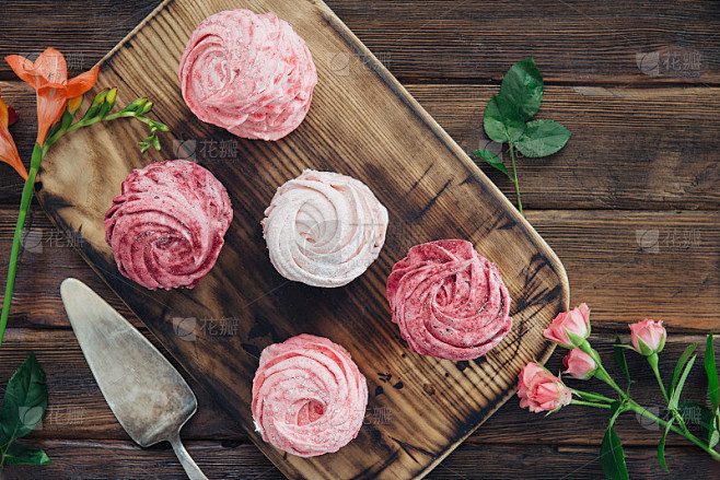 由各种蓝莓、樱桃、蛋白酥皮和花朵组成，以木质为背景