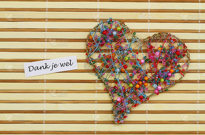 “Dank je wel”(荷兰语中“谢谢”的意思)的心是用彩色的珠子做成的，放在竹席上