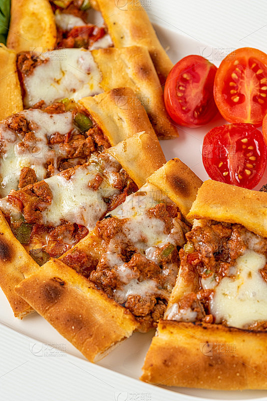 切成薄片的“u200b”u200bous肉馅皮塔饼和沙拉放在石头桌上。