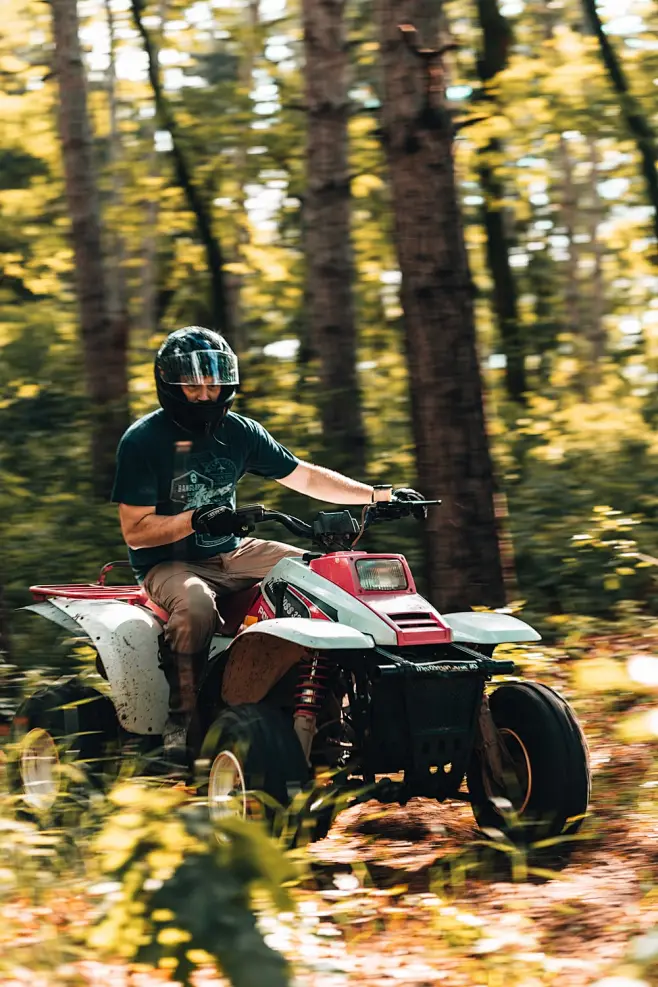 man riding atv in forest during daytime-花瓣网