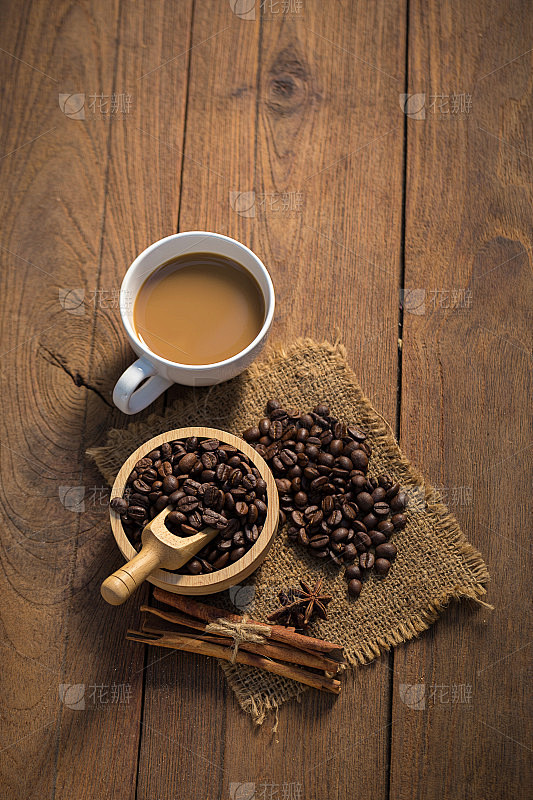 木质背景上的咖啡杯和咖啡豆。