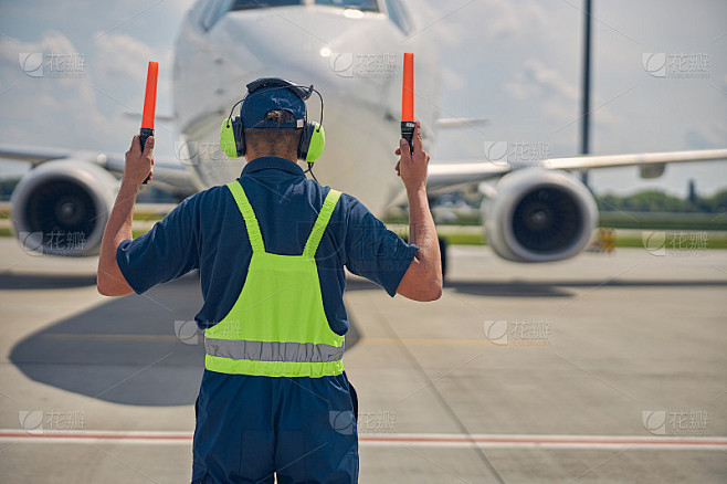Marshaller in the safety overalls signaling the pi