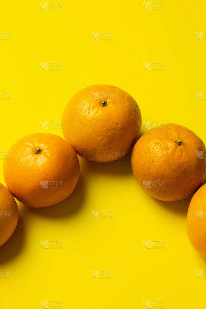 High angle view of tangerines in peel on yellow ba
