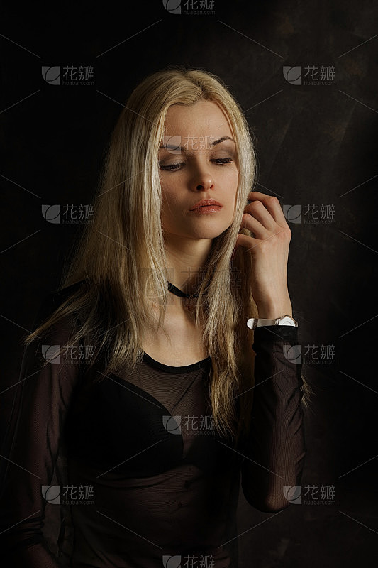 一个美丽的金发女孩的肖像在一个黑色的背景