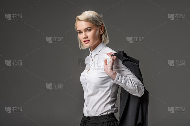 侧面的时尚的年轻女子在白衬衫摆姿势