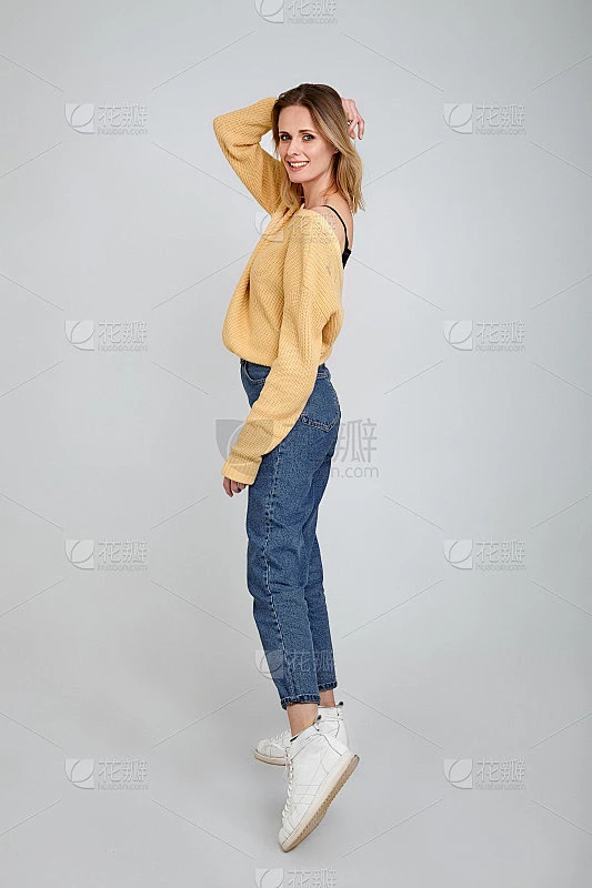 苗条和漂亮。全长工作室拍摄的迷人的年轻女子在休闲穿着微笑，握着她的头发，而站在灰色的背景素材 花瓣网 6129