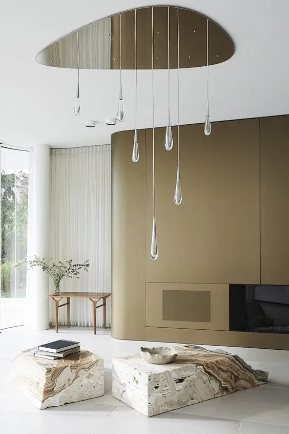 A brushed brass fireplace surround subtly repeats the architectural curves. The bespoke ceiling ...