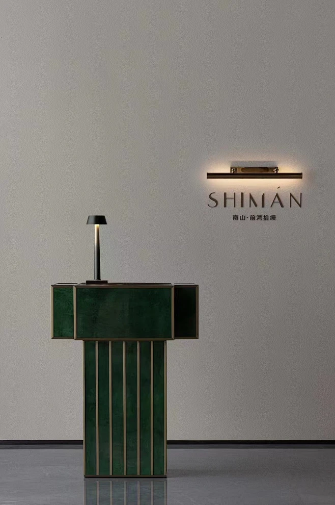 This may contain: a green table with a lamp on it in front of a sign ...