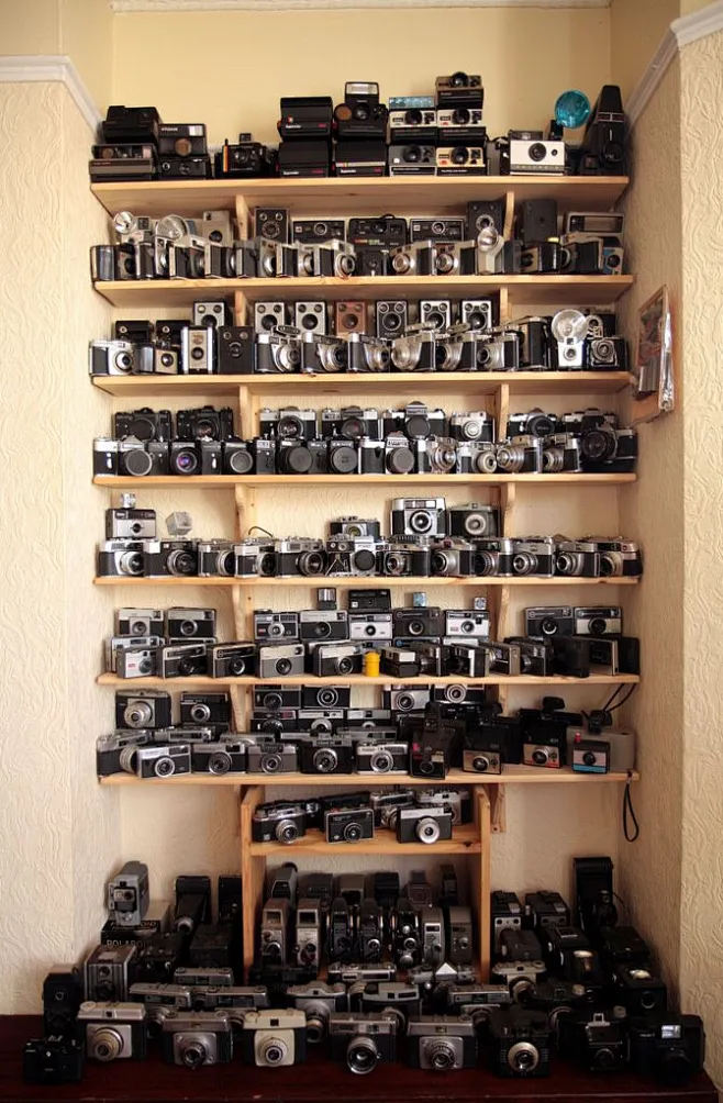 This may contain: black and white photograph of many cameras on shelves-花瓣网