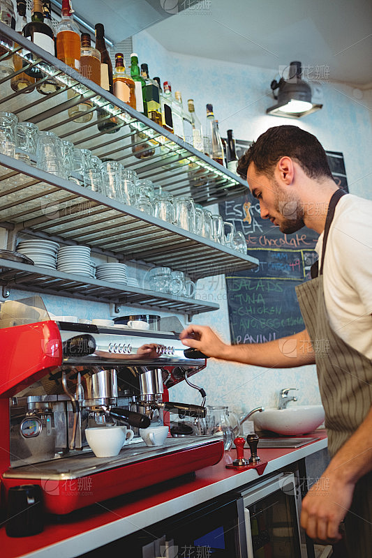 咖啡馆服务员使用咖啡机的侧视图