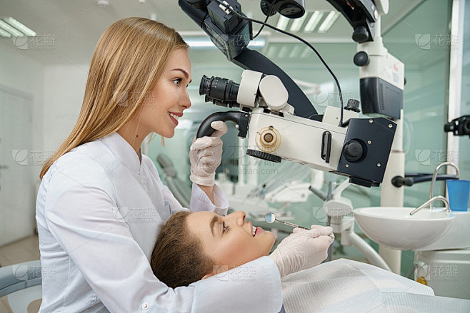 牙医用现代牙科显微镜检查牙齿。