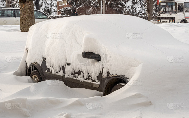 暴风雪过后的城市街道。汽车被困在雪和冰下。被埋在路上积雪中的车辆。冬季大雪后的停车场。未弄清洁的道路