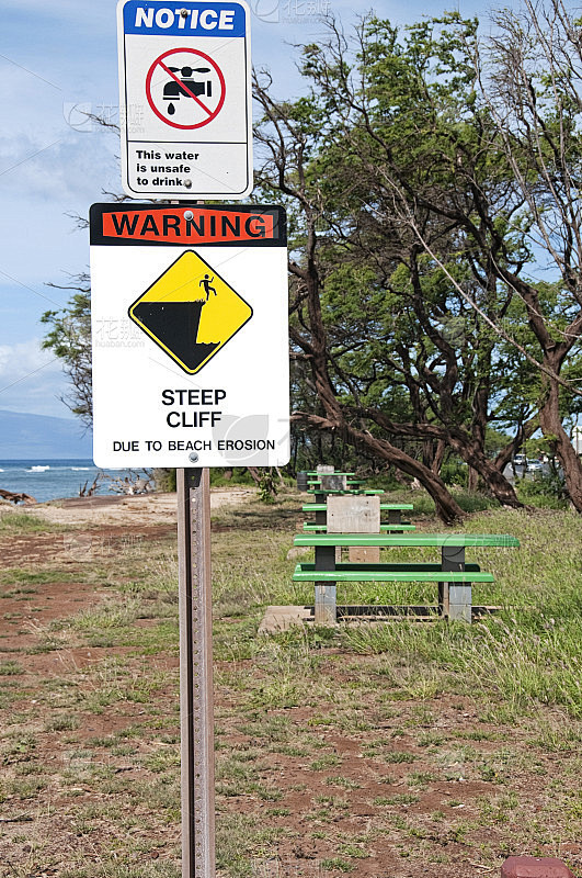 毛伊岛海滩上的警告标志和野餐桌